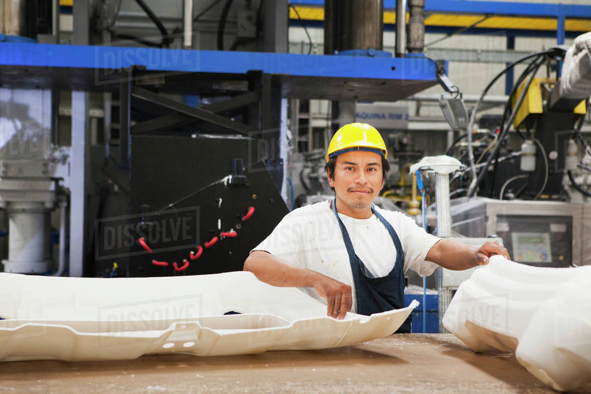 Worker smiling in manufacturing plant - Stock Photo - Dissolve