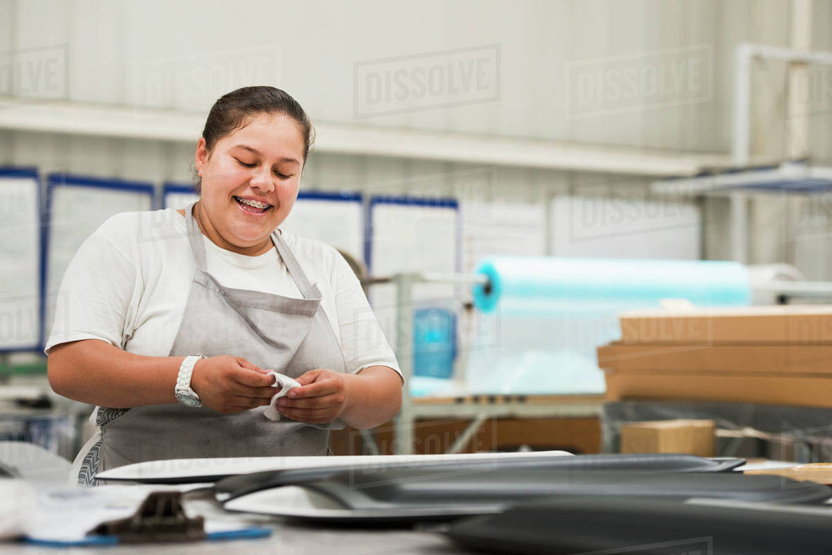 Worker smiling in manufacturing plant - Royalty-free Stock Photo | Dissolve