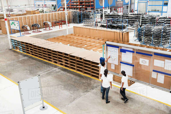 Workers reading bulletin board in manufacturing plant - Stock Photo ...
