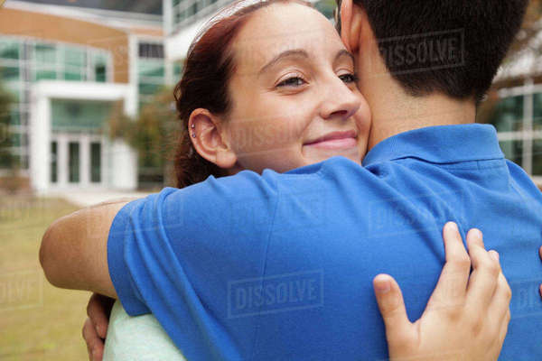 Students hugging on campus - Stock Photo - Dissolve