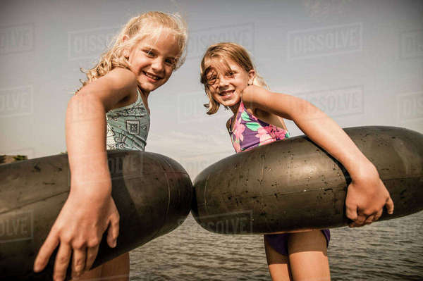 Caucasian girls with inner tubes in water - Royalty-free Stock Photo ...