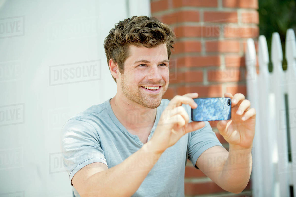 Man using cell phone outdoors - Royalty-free Stock Photo | Dissolve