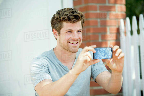 Man using cell phone outdoors - Royalty-free Stock Photo | Dissolve