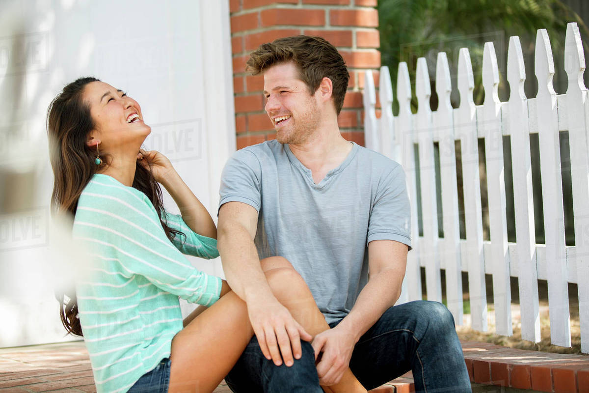 Couple laughing together outdoors - Stock Photo - Dissolve