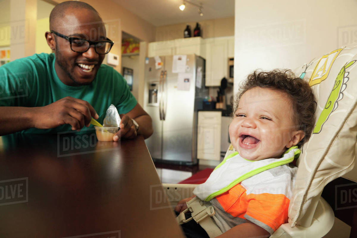 Father feeding baby at table - Royalty-free Stock Photo | Dissolve