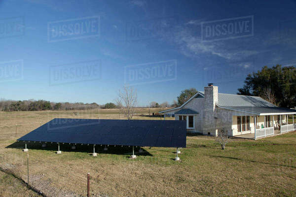 Solar panels outside home in rural landscape - Stock Photo - Dissolve