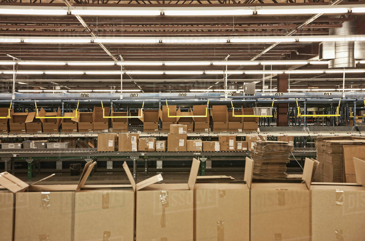 Cardboard boxes along production line in warehouse - Stock Photo - Dissolve