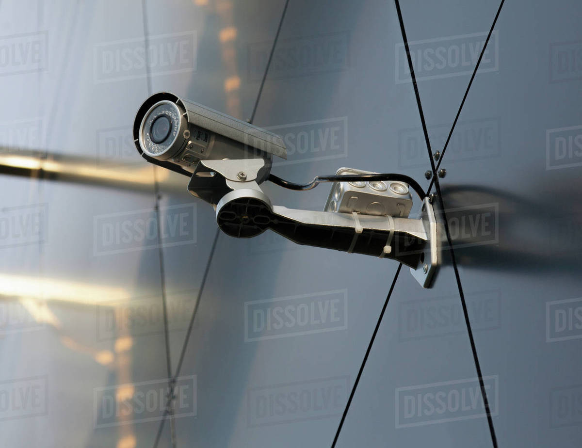 A security camera mounted on the wall of a building - Royalty-free ...