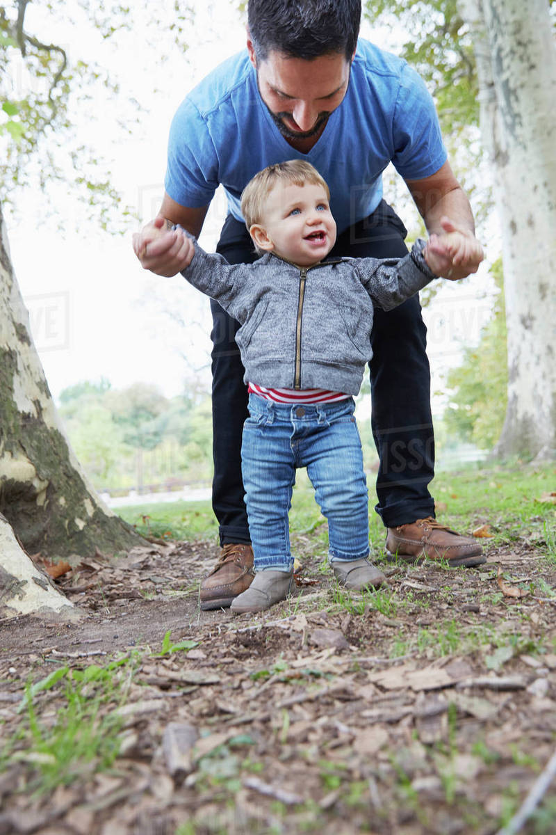 Caucasian father helping baby son walk outdoors - Royalty-free Stock ...