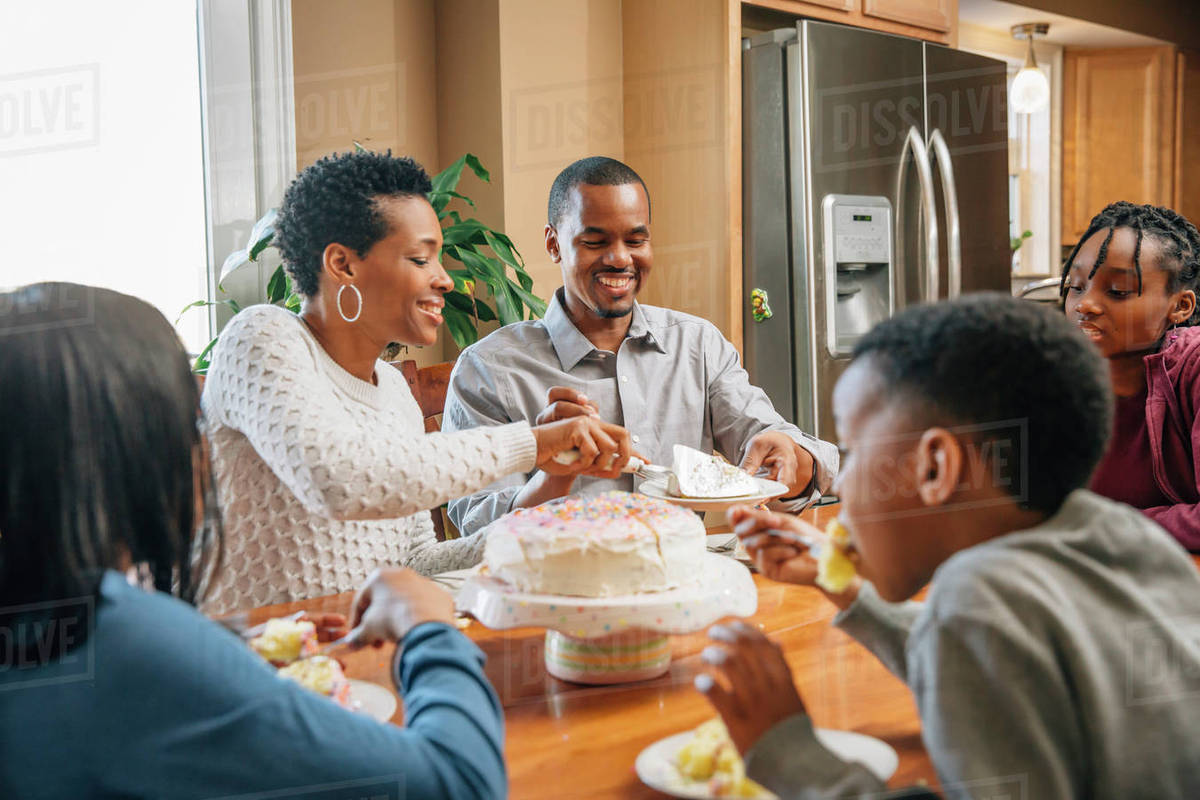 Black family eating cake at birthday party - Stock Photo - Dissolve