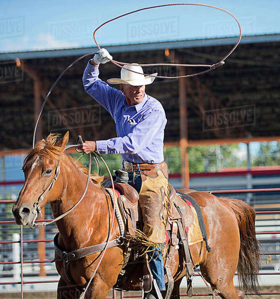 Older Caucasian cowboy throwing lasso at rodeo - Royalty-free Stock ...