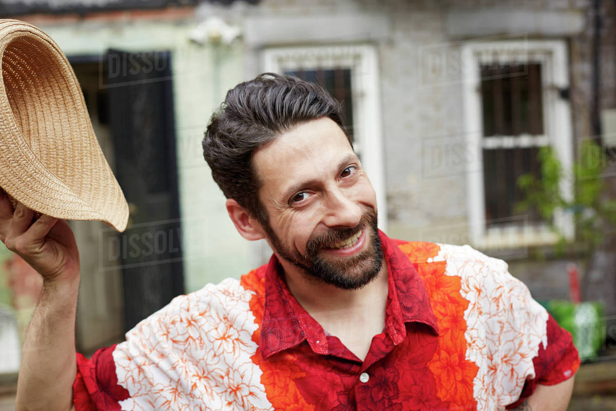 Caucasian man tipping straw hat in backyard - Royalty-free Stock Photo ...
