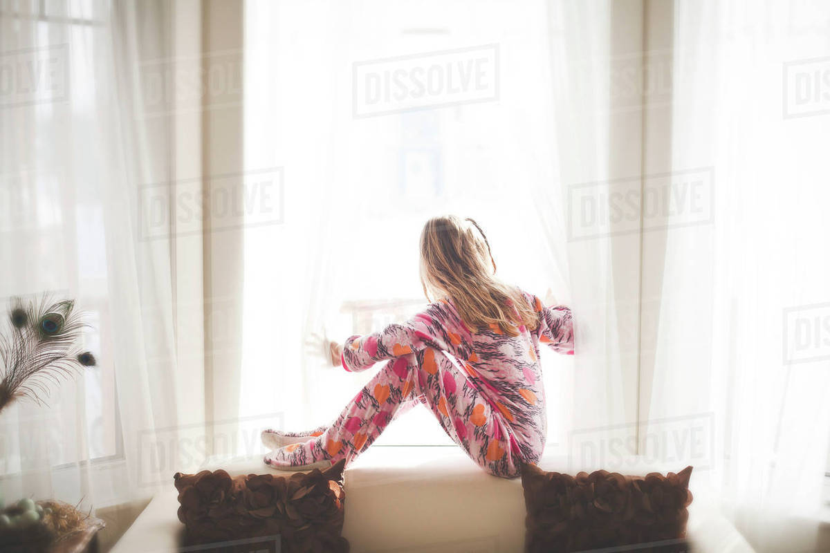 Caucasian girl sitting in window - Stock Photo - Dissolve