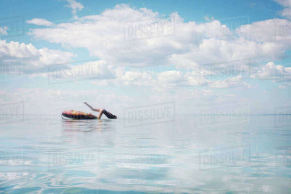 Caucasian teenage girl jumping from inner tube into lake - Stock Photo ...