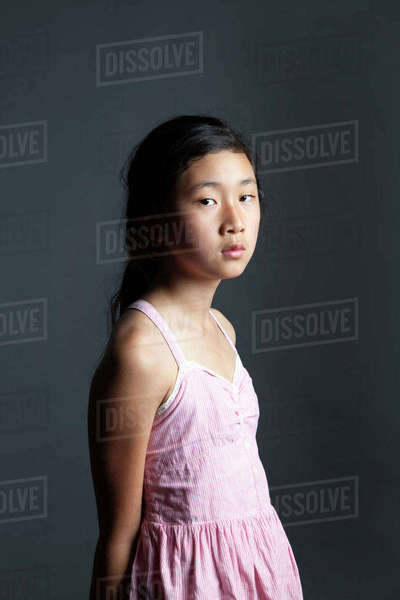 Serious Asian girl wearing dress - Stock Photo - Dissolve