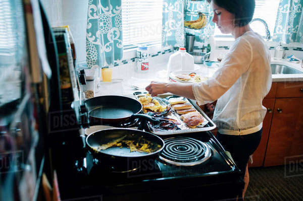 Woman cooking breakfast in kitchen - Stock Photo - Dissolve