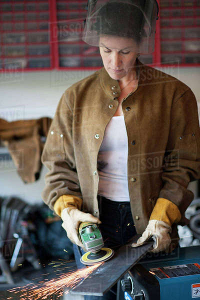 Artisan grinding metal in garage workshop - Stock Photo - Dissolve