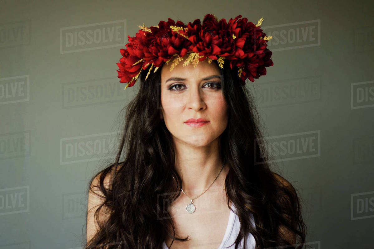 Serious woman wearing flower crown - Stock Photo - Dissolve