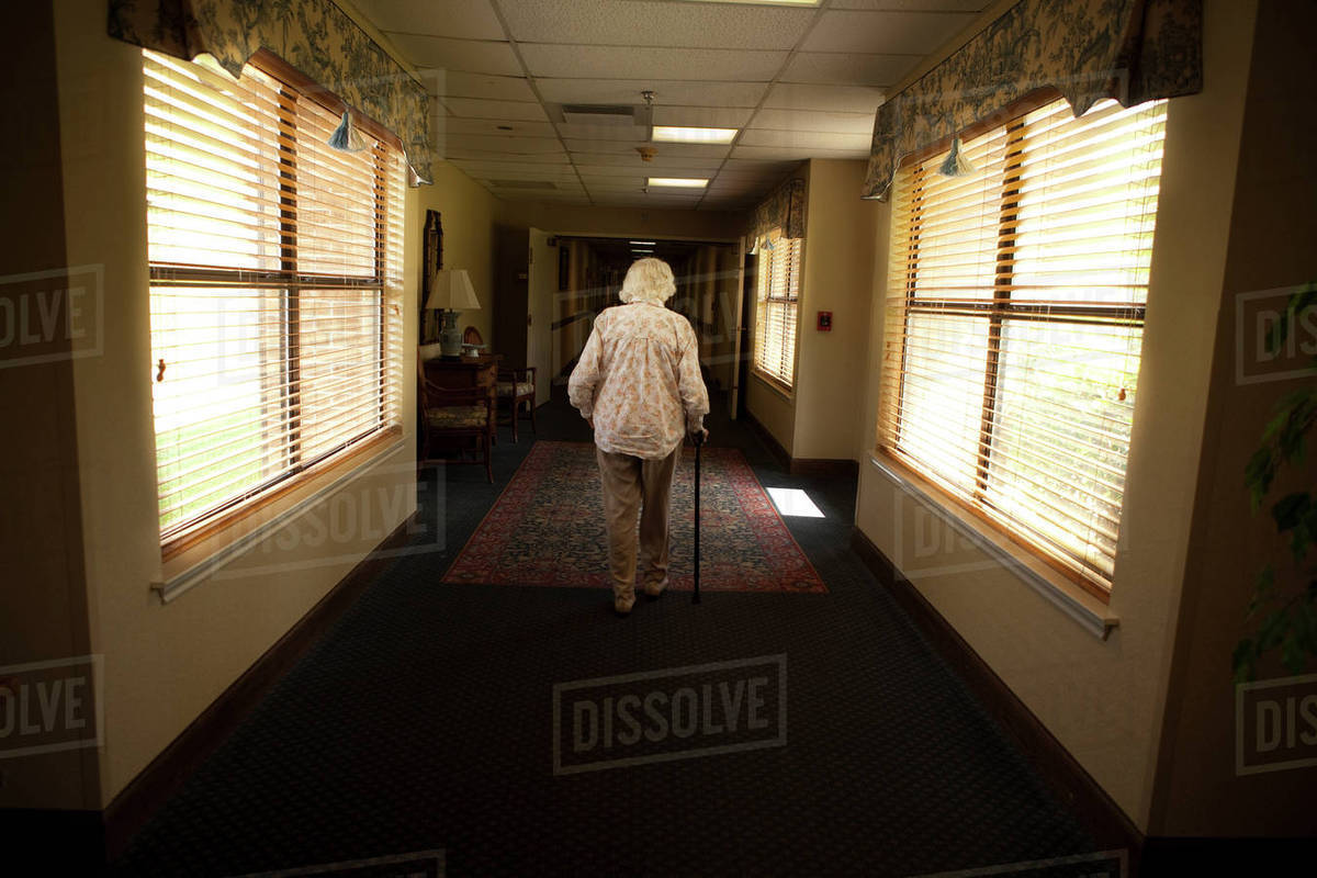 Older Caucasian woman walking with cane in retirement home - Stock ...