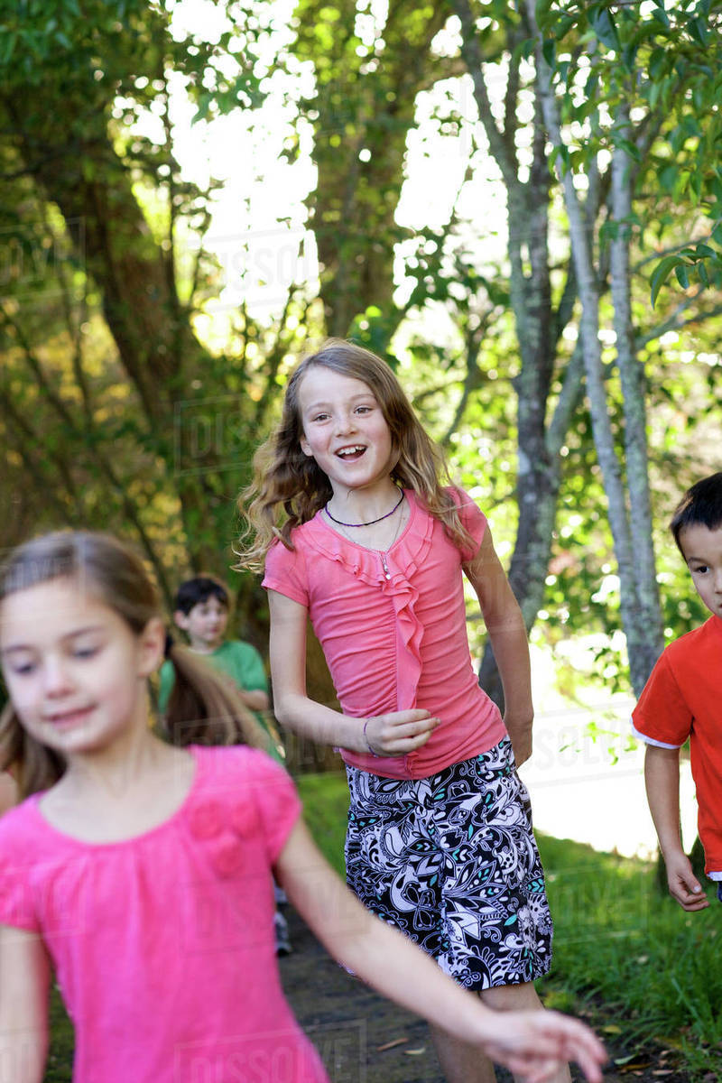Children running on dirt path in park - Stock Photo - Dissolve