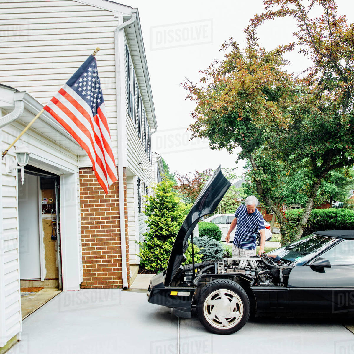 Caucasian man repairing car in driveway - Royalty-free Stock Photo ...
