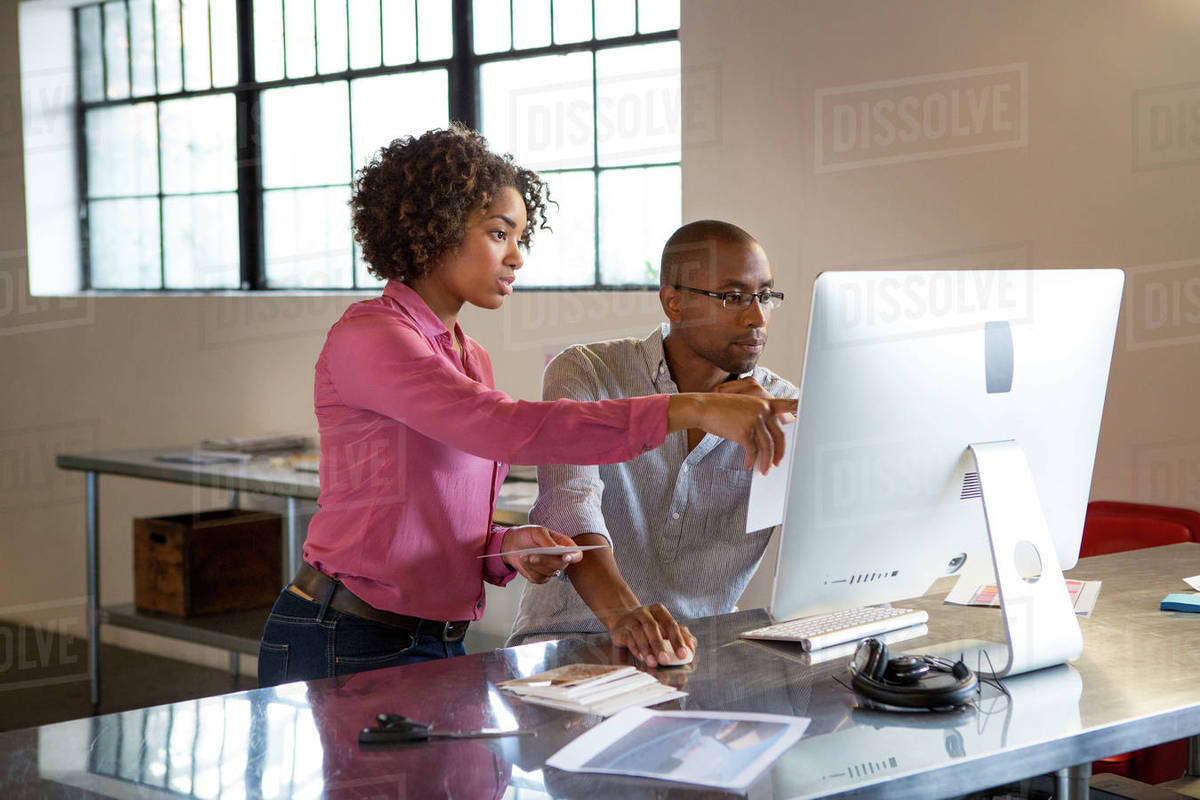 Business people using computer in office - Stock Photo - Dissolve
