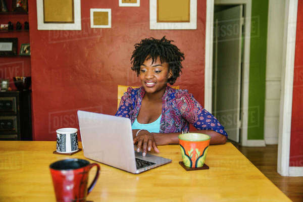 Black woman using laptop - Stock Photo - Dissolve