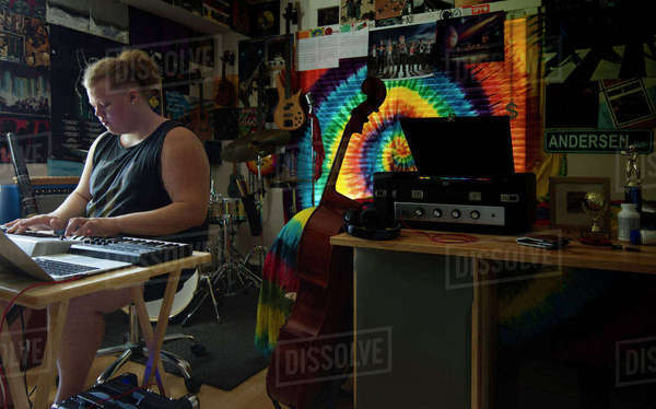 Caucasian man playing keyboard in music studio - Stock Photo - Dissolve