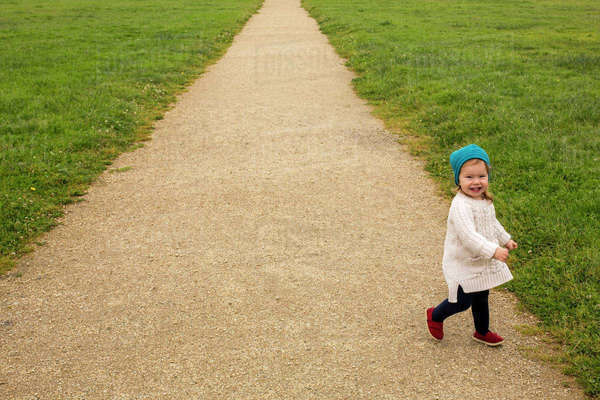 Smiling Caucasian baby girl walking on path - Royalty-free Stock Photo ...
