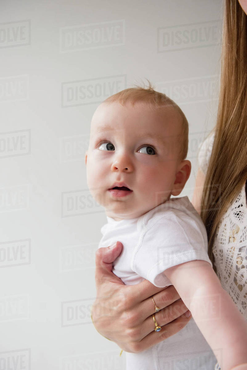 Caucasian baby boy looking back at mother - Stock Photo - Dissolve