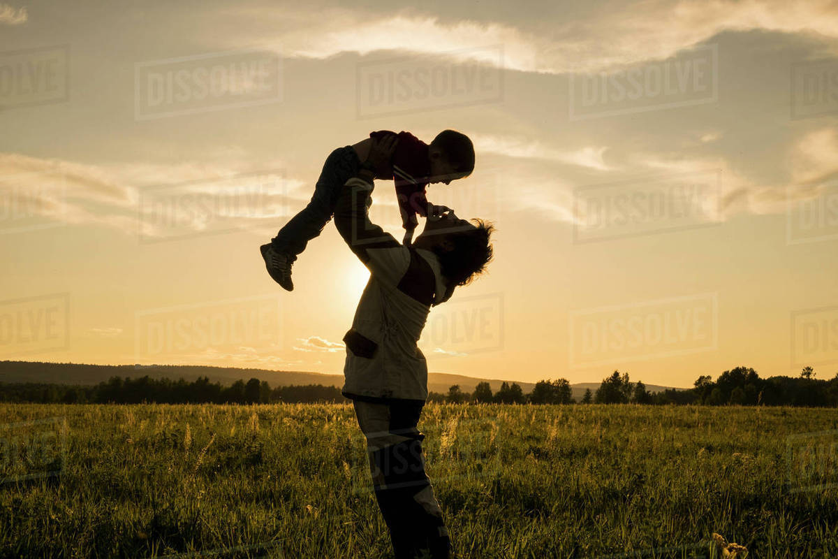 Mari man lifting son in field at sunset - Royalty-free Stock Photo ...