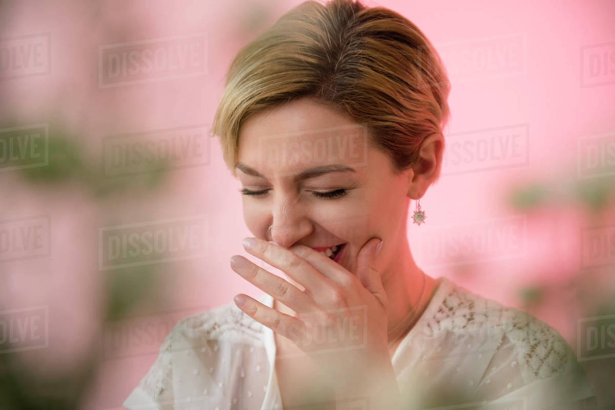 Caucasian woman covering mouth while laughing - Royalty-free Stock ...
