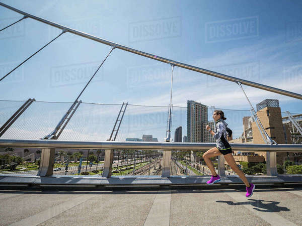 Caucasian woman running on bridge - Royalty-free Stock Photo | Dissolve