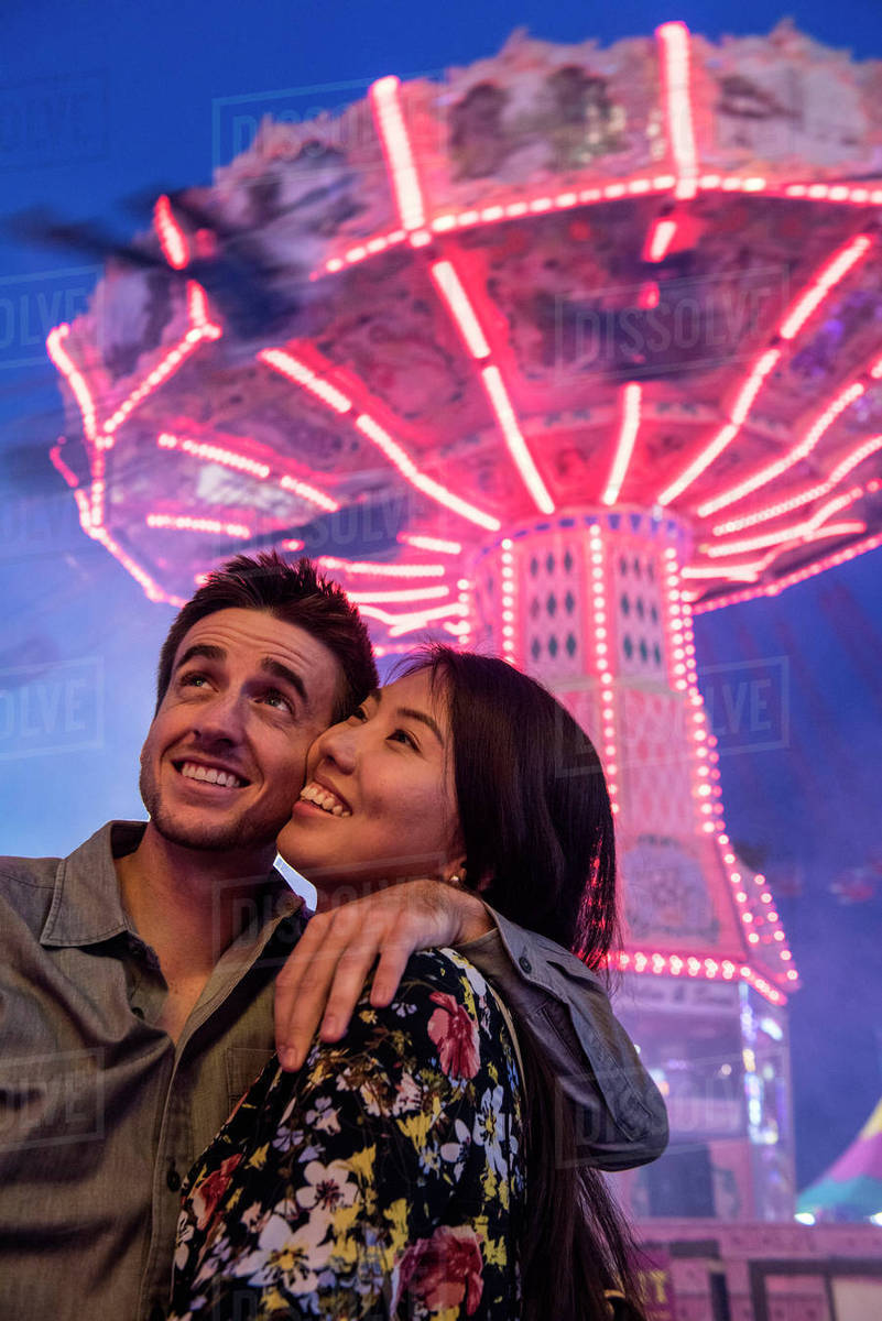 Smiling couple cheek to cheek in amusement park - Royalty-free Stock ...