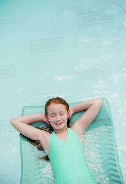 Caucasian girl floating on pool raft in swimming pool - Stock Photo ...