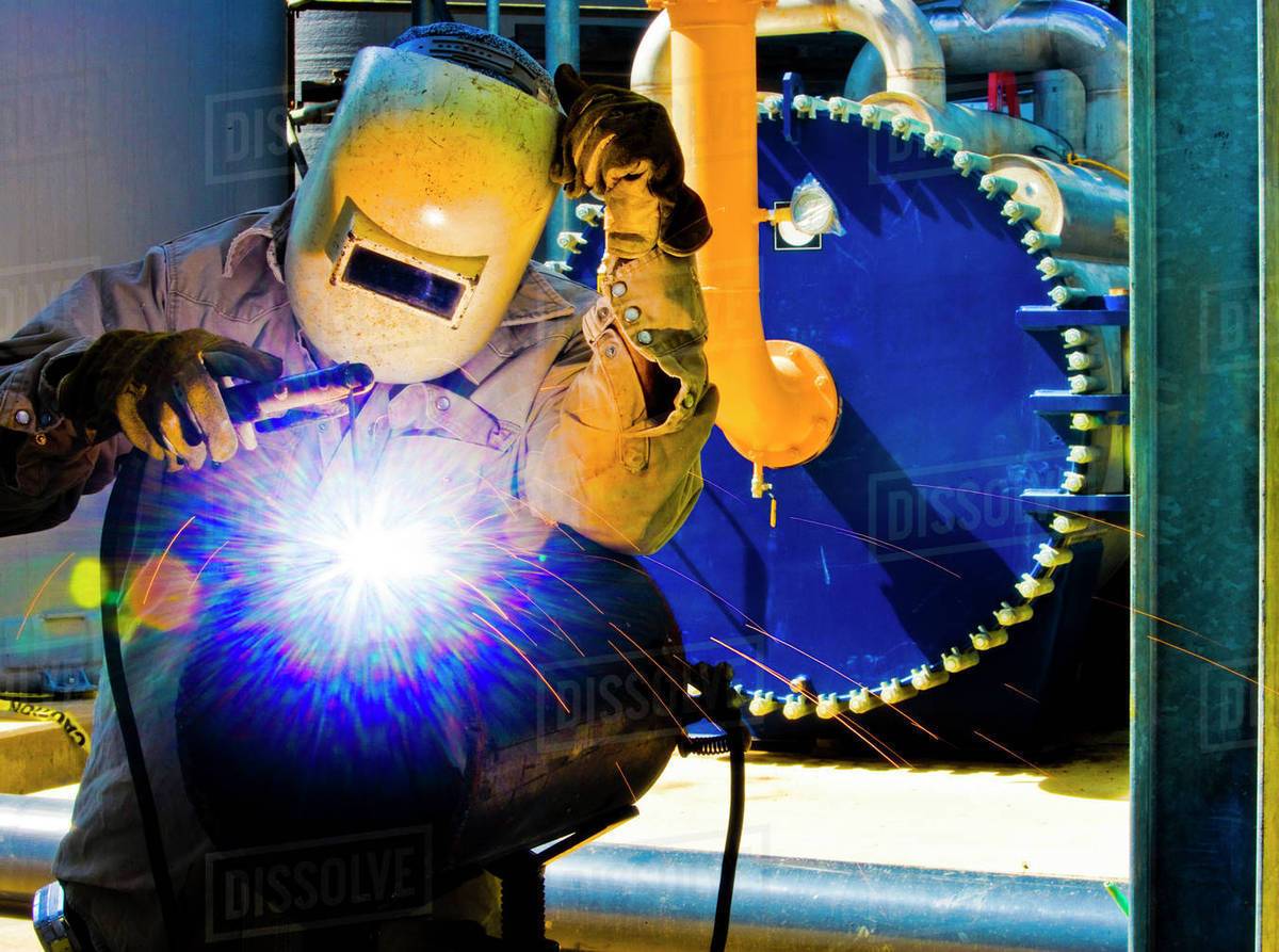 Caucasian welder working in factory - Stock Photo - Dissolve