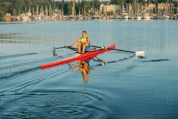 Caucasian man rowing on lake - Royalty-free Stock Photo | Dissolve