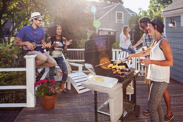 Friends enjoying barbecue on patio - Royalty-free Stock Photo | Dissolve
