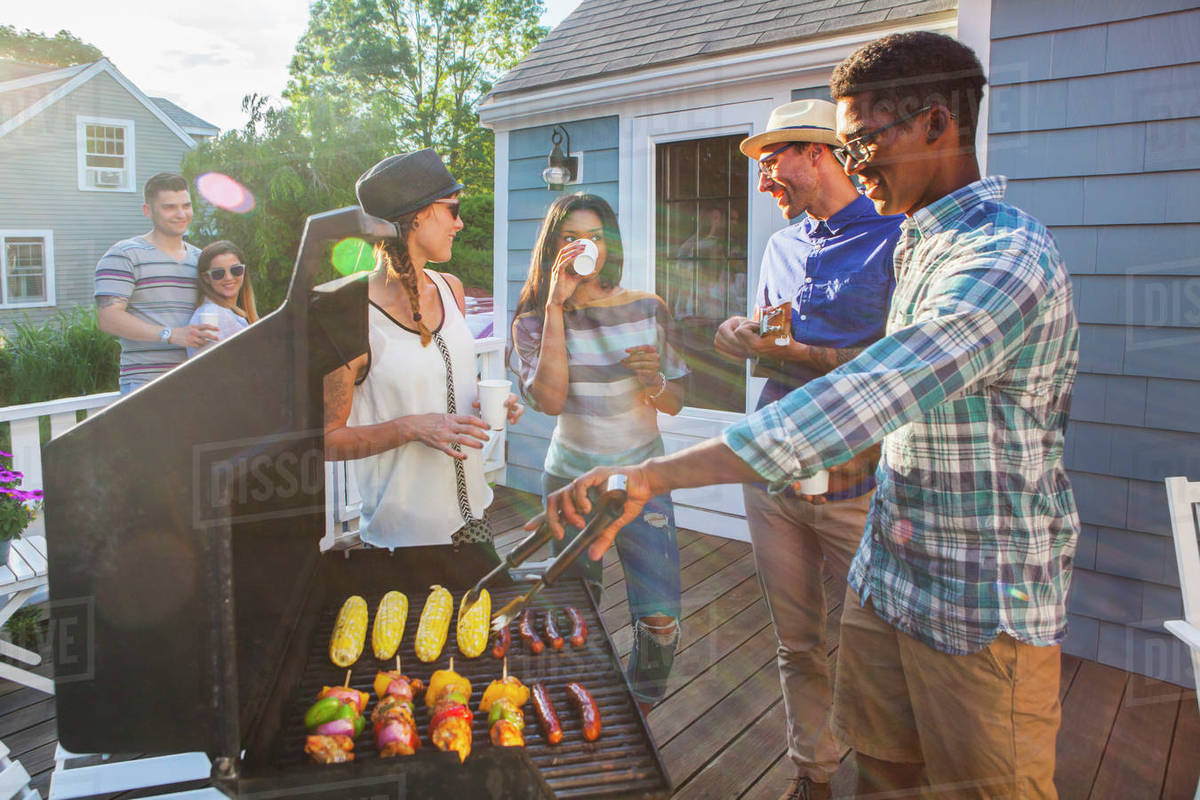 Friends enjoying barbecue on patio - Royalty-free Stock Photo | Dissolve