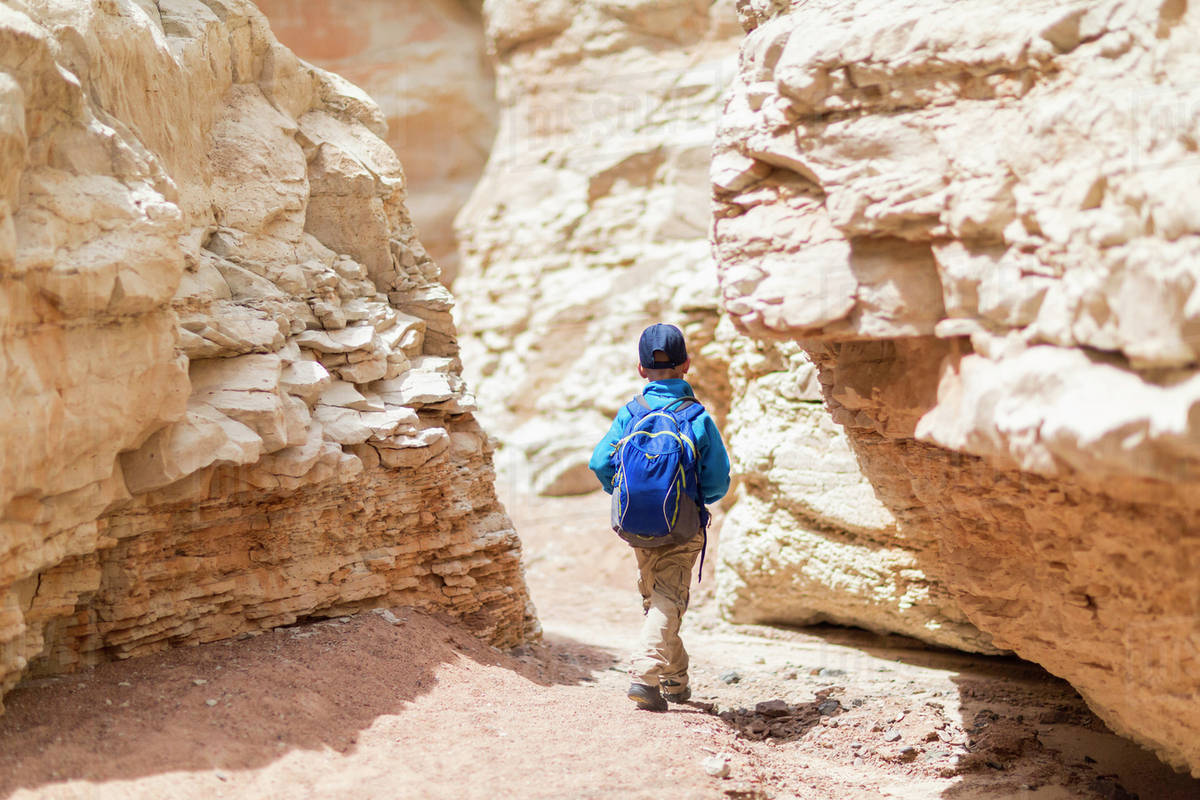 Boy exploring desert rock formations - Royalty-free Stock Photo | Dissolve