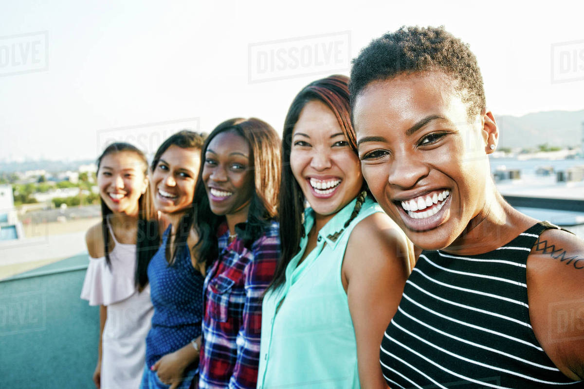 Smiling women standing in a row on rooftop - Royalty-free Stock Photo ...
