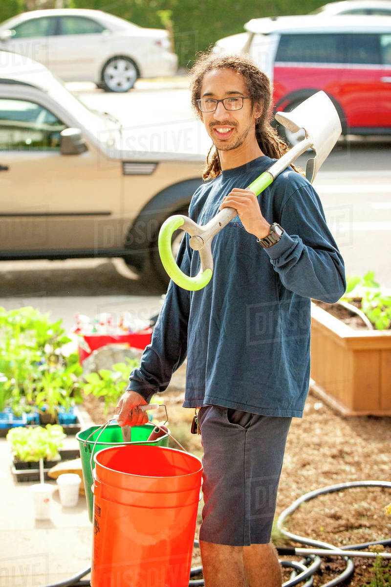 Portrait of smiling Black man holding shovel and buckets - Stock Photo ...