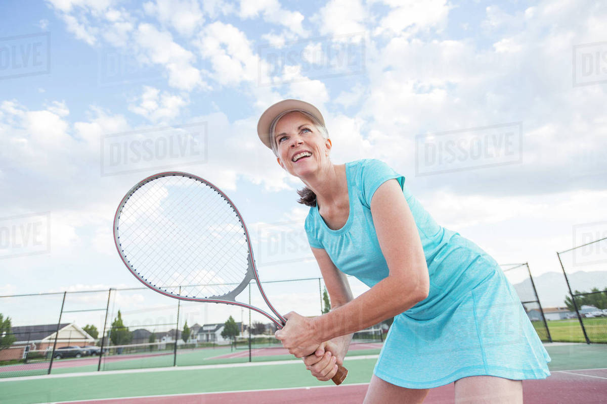 Caucasian woman holding tennis racket - Stock Photo - Dissolve