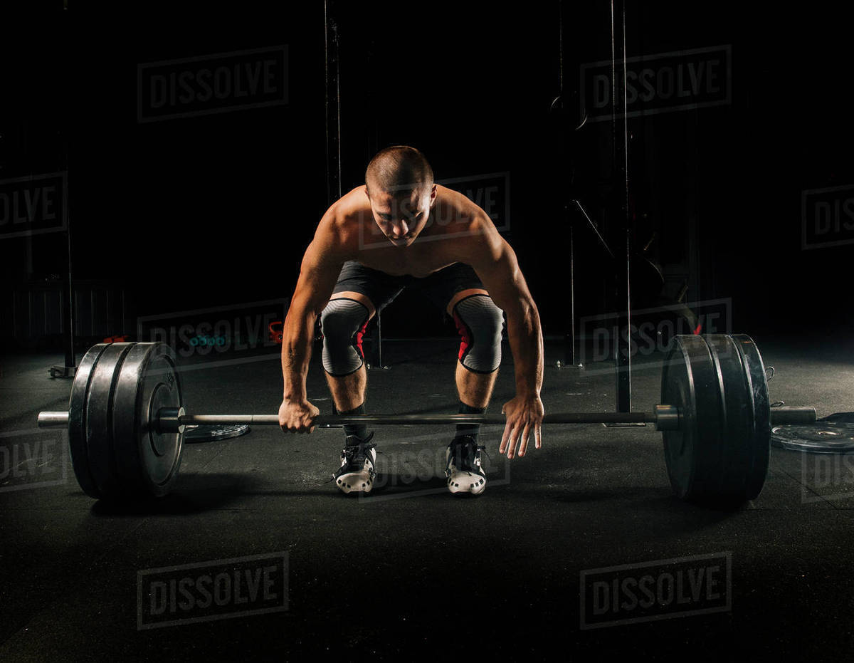 Man lifting heavy barbell in gymnasium - Royalty-free Stock Photo ...