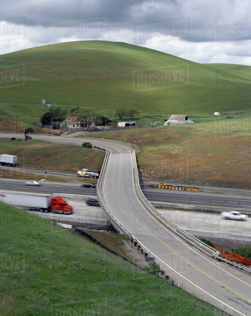 Trucks and cars driving under freeway overpass - Royalty-free Stock ...