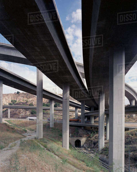 Trucks and cars driving under freeway overpass - Royalty-free Stock ...