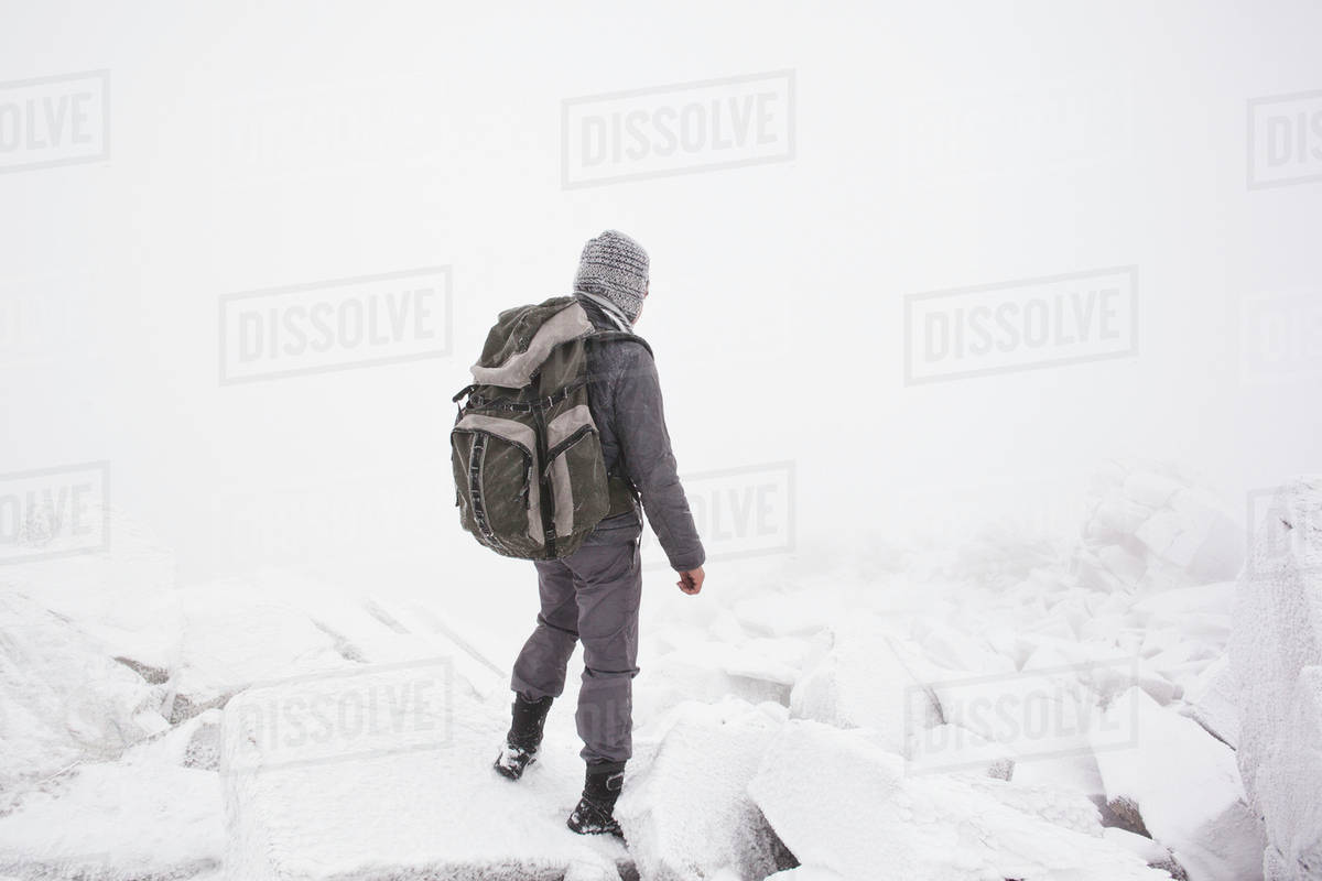 Caucasian man hiking in snow - Royalty-free Stock Photo | Dissolve
