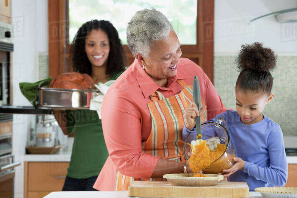 Three generations of Black women cooking in kitchen - Stock Photo ...