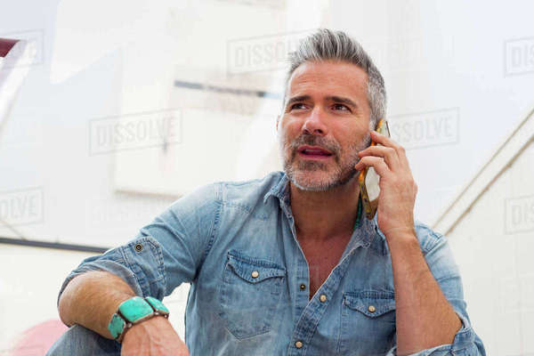 Caucasian man talking on cell phone - Stock Photo - Dissolve