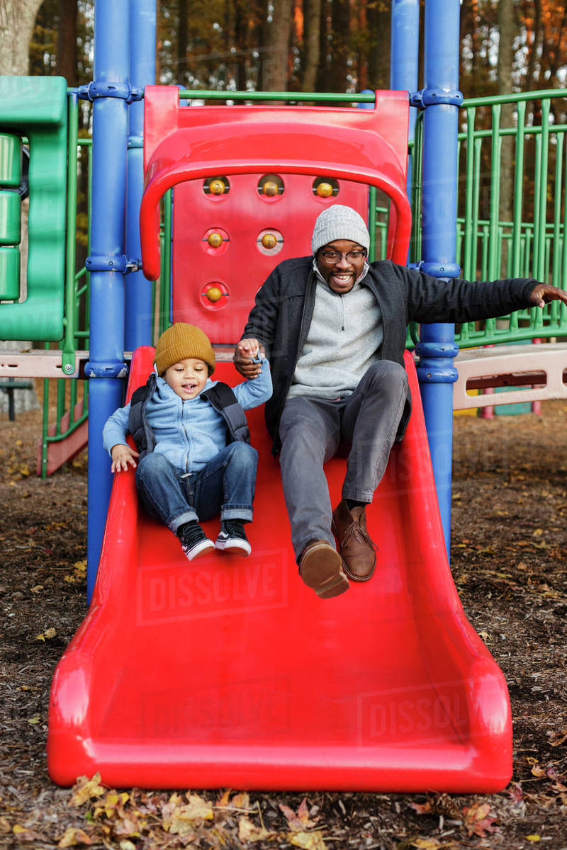 Father and son on playground slide in park - Royalty-free Stock Photo ...